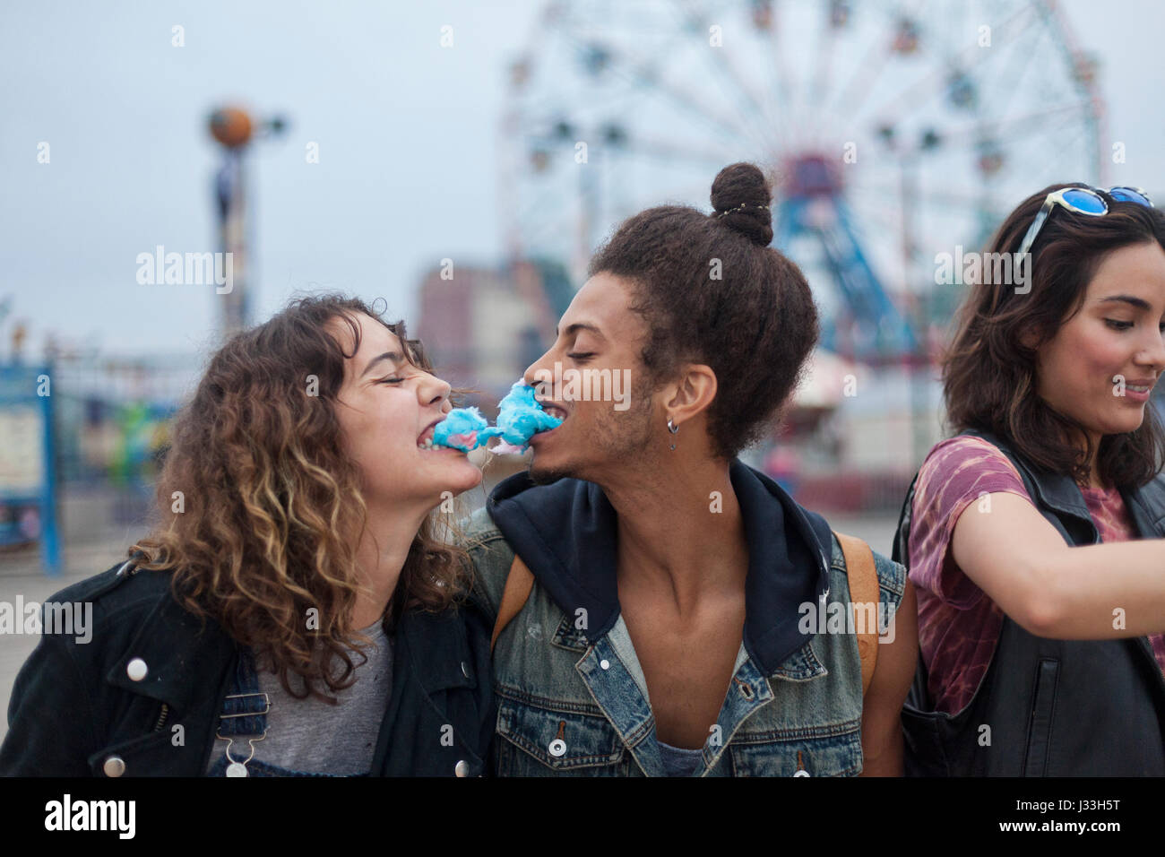 Friends eating cotton candy at an amusement park Stock Photo - Alamy