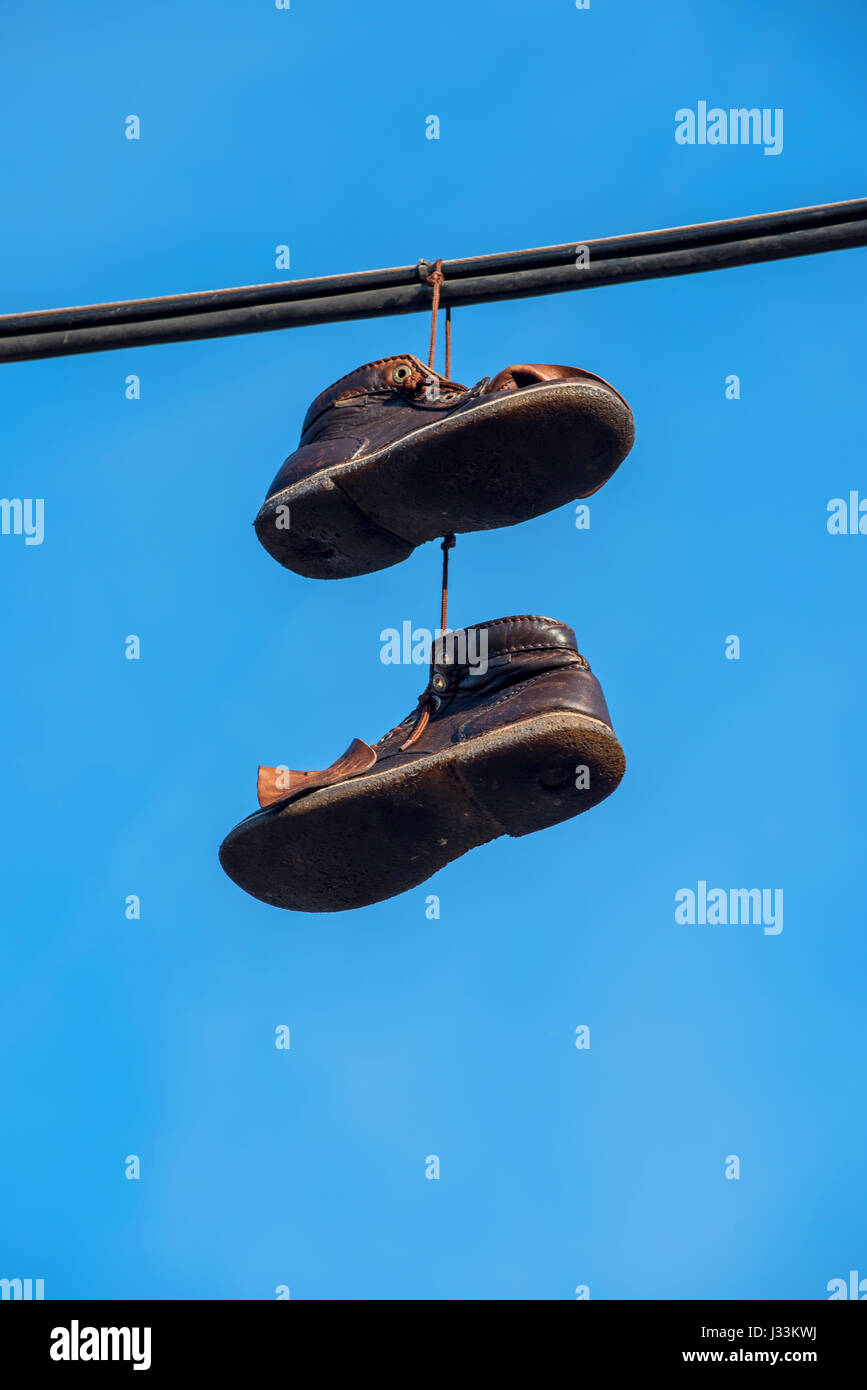 Shoes Hanging on a Wire with blue sky Stock Photo - Alamy