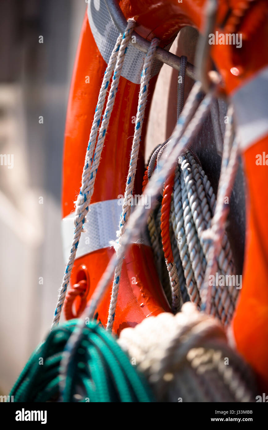 Safety bright red lifebuoy and ropes for secure swimming hooked on the ...