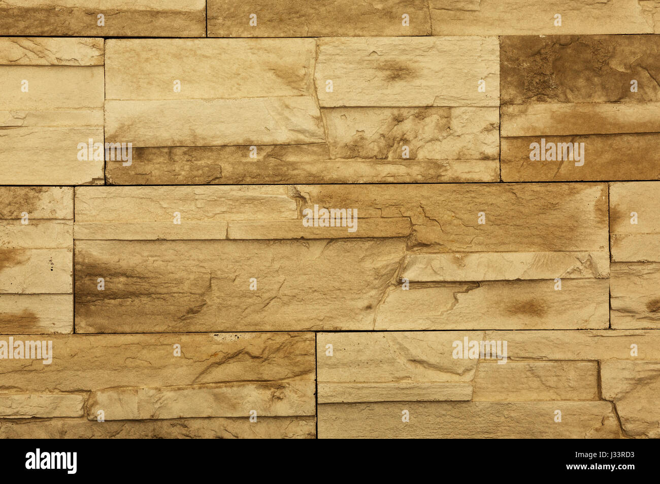 Old stone wall with rectangular yellow stones with visible structure ...