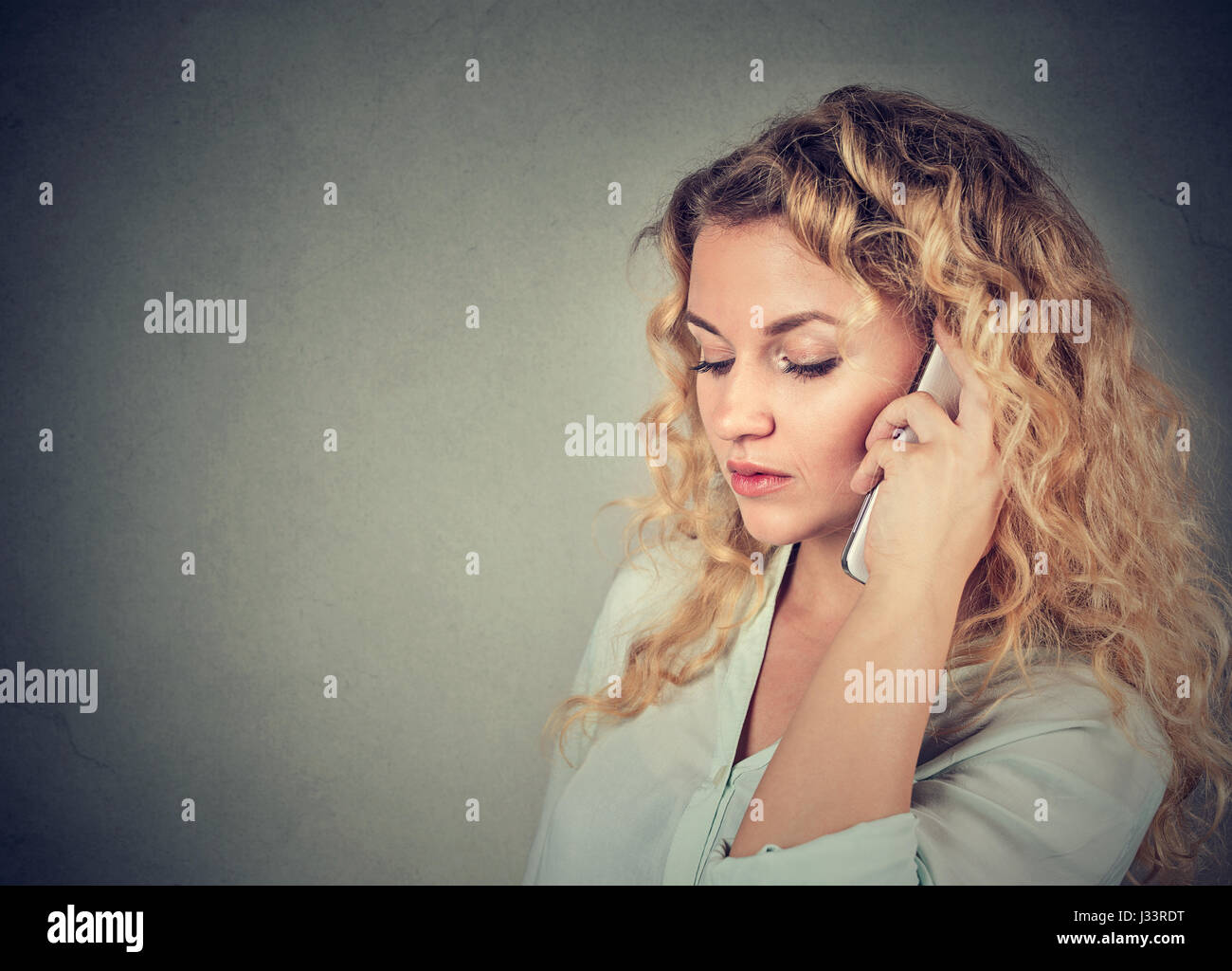 Young sad woman talking on mobile phone Stock Photo - Alamy