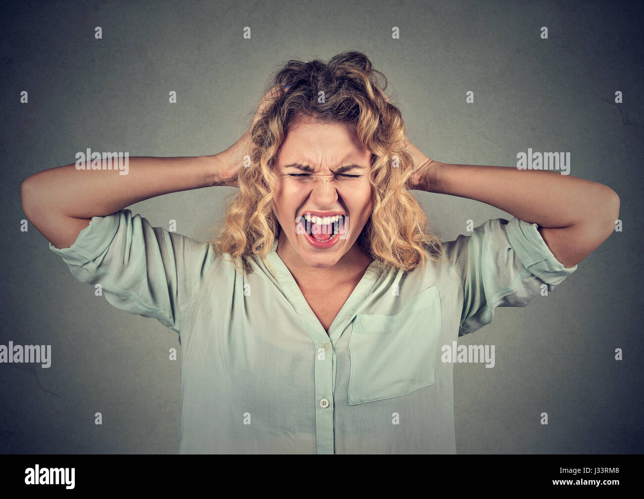 Stressed angry woman yelling screaming has temper tantrum isolated gray ...