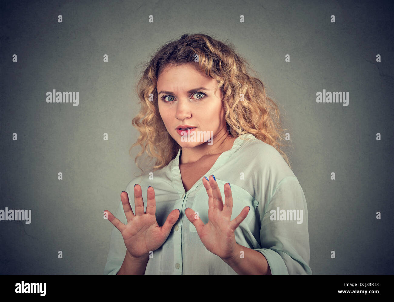 scared woman raising hands up in defense afraid about to be attacked or ...