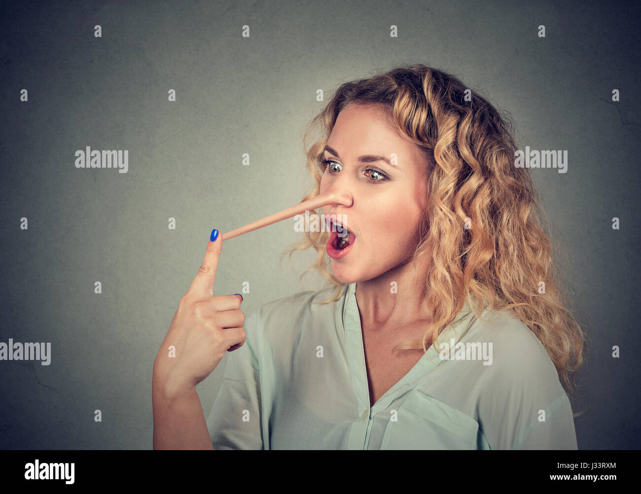 Woman with long nose isolated on grey wall background. Liar concept ...