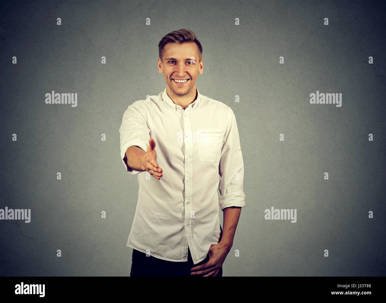 Happy smiling man giving hand for an handshake Stock Photo - Alamy
