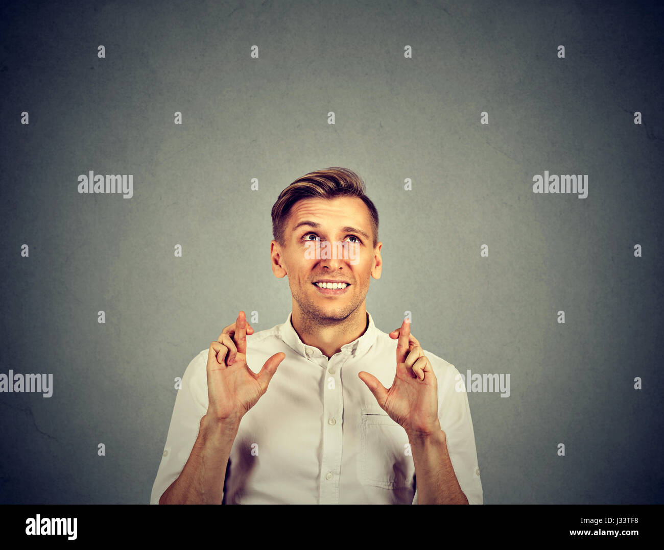 Young man making a wish keeping his fingers crossed Stock Photo - Alamy