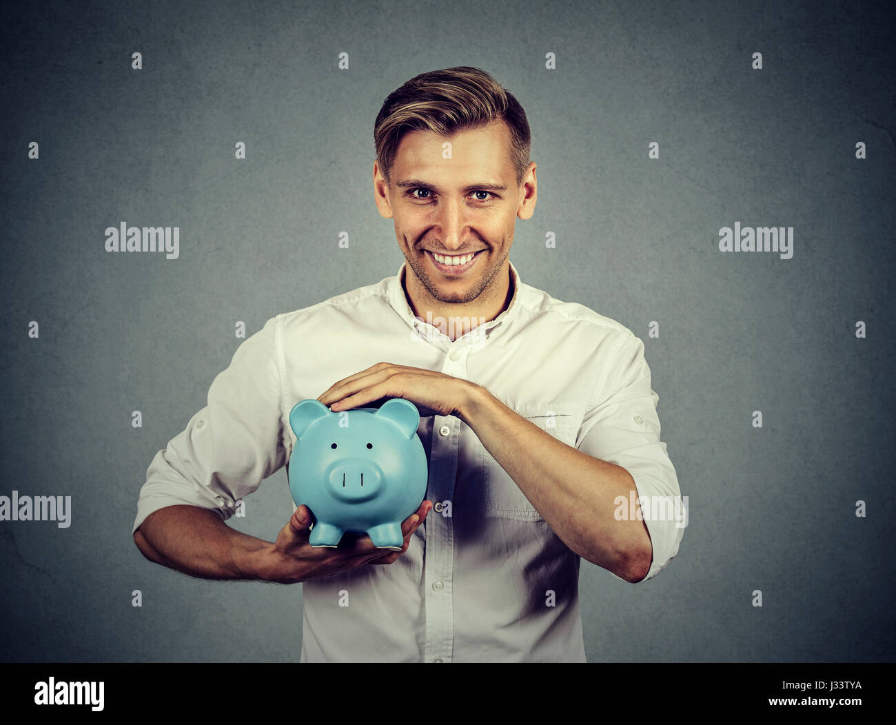 Man with piggy bank isolated on gray wall background Stock Photo - Alamy