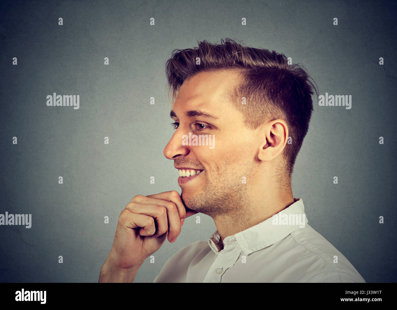 Side view of handsome happy man daydreaming isolated on gray background ...