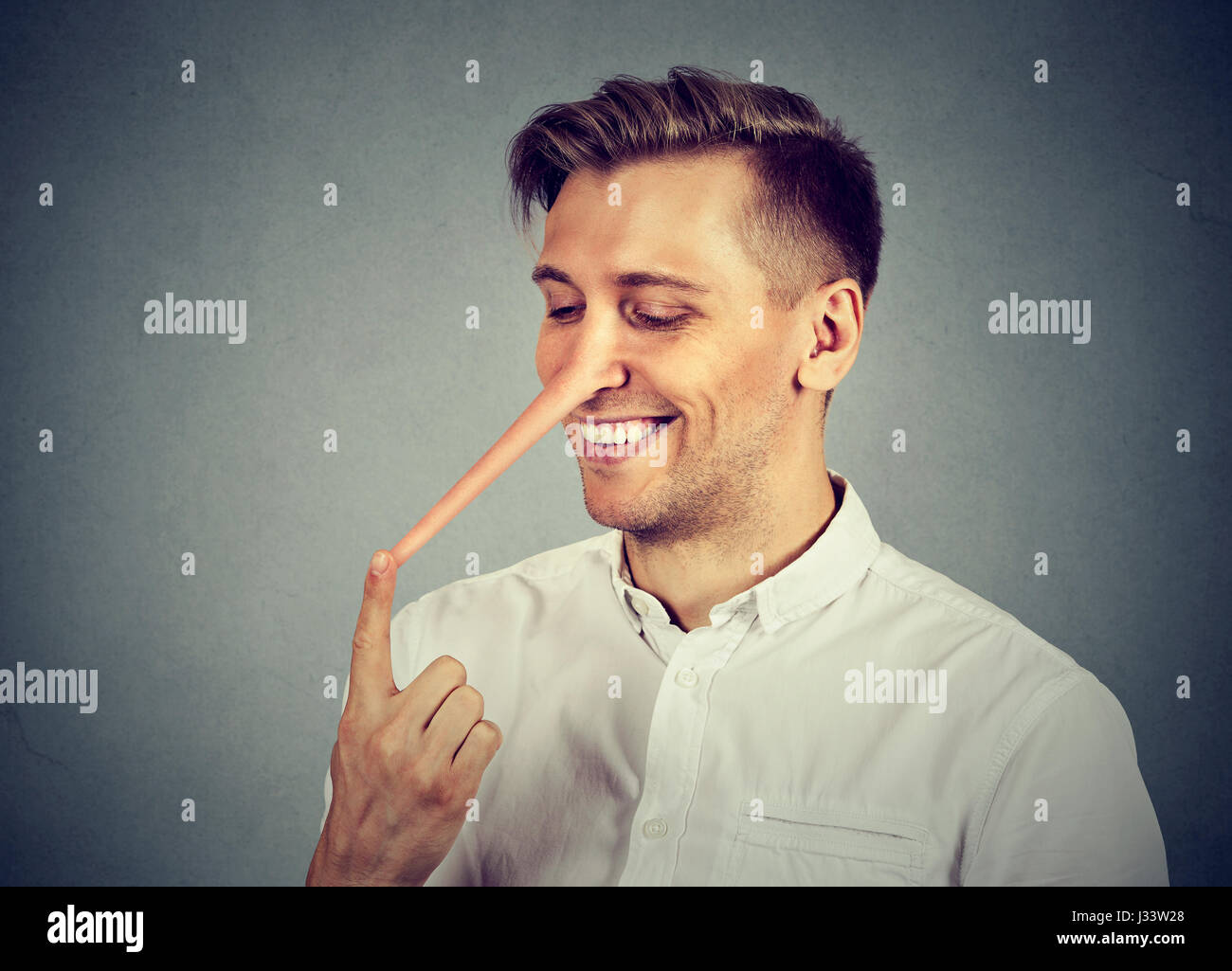 Man with long nose isolated on grey wall background. Liar concept ...