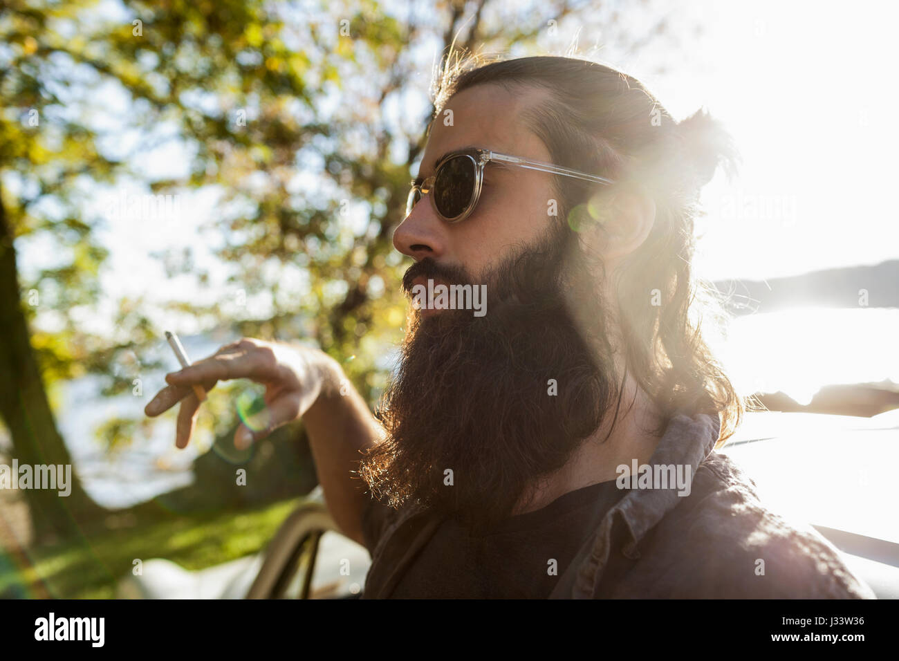 Handsome young man smoking a cigarette Stock Photo - Alamy