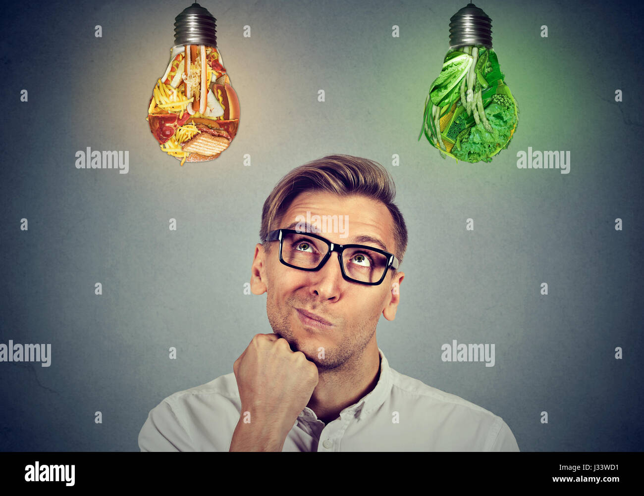 Man in glasses thinking looking up at vegetables light bulbs craving ...