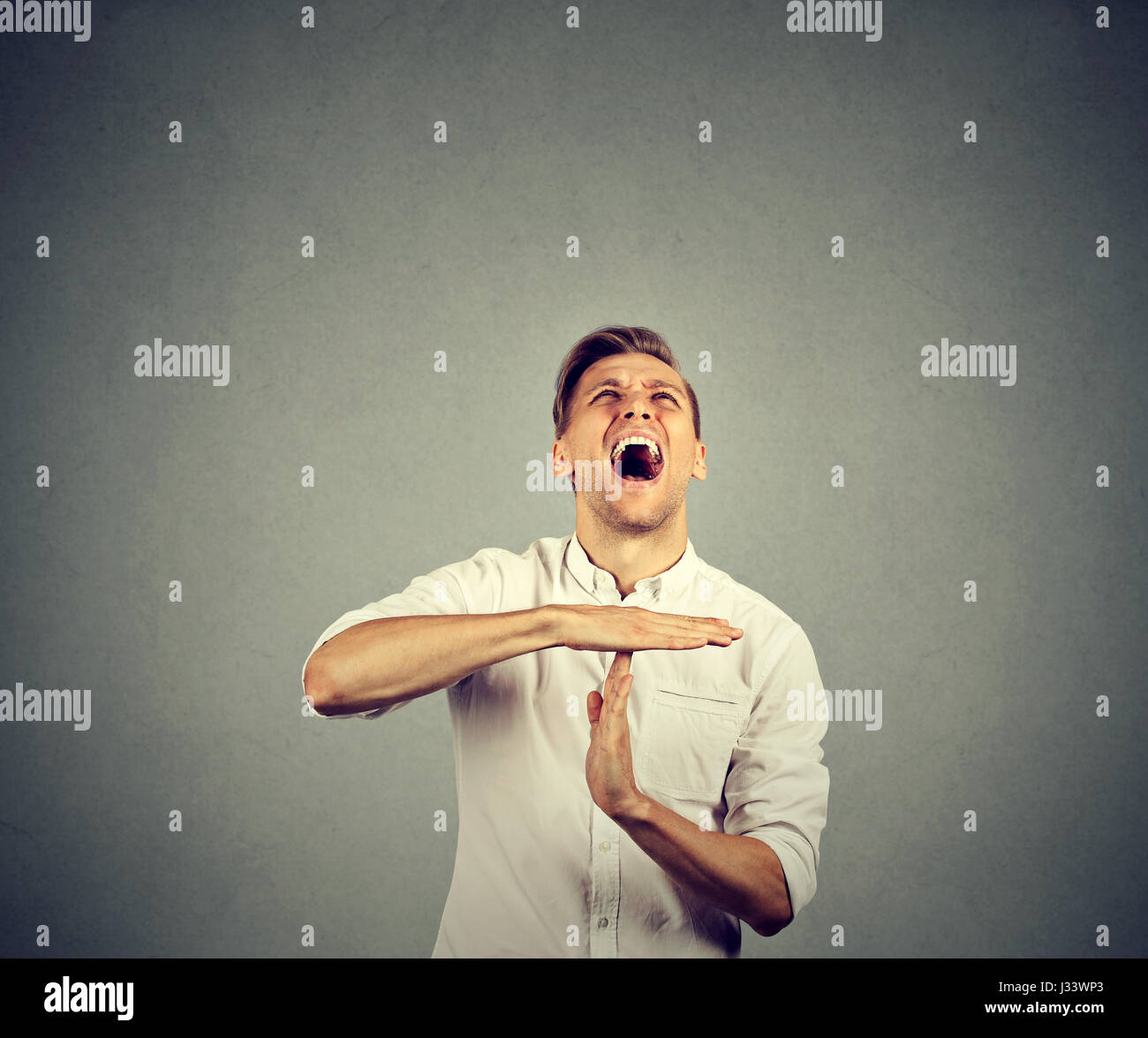 Young man showing time out hand gesture, frustrated screaming to stop ...