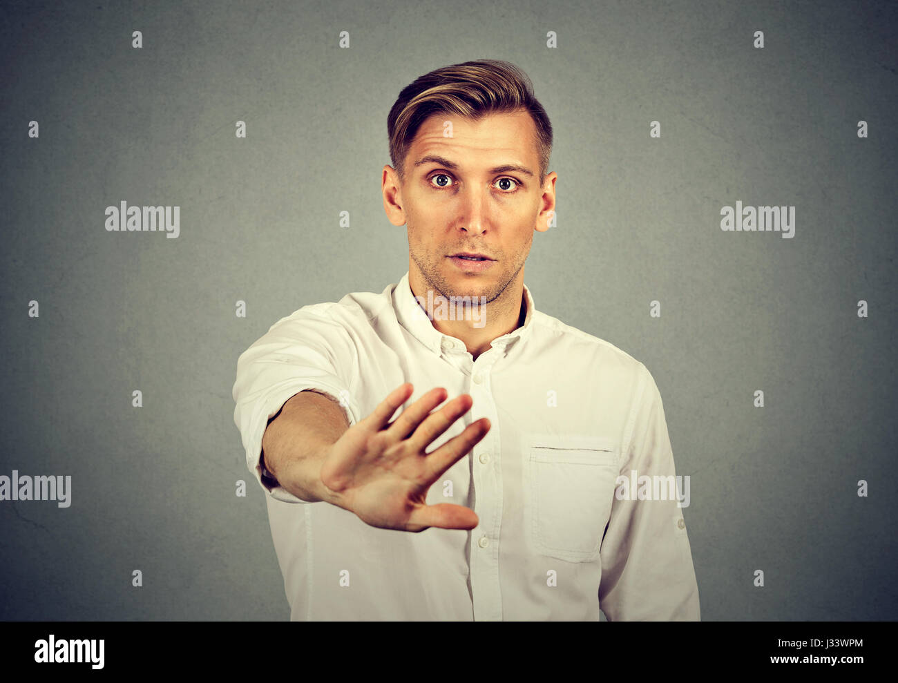 young man with stop hand gesture isolated on gray wall background Stock ...