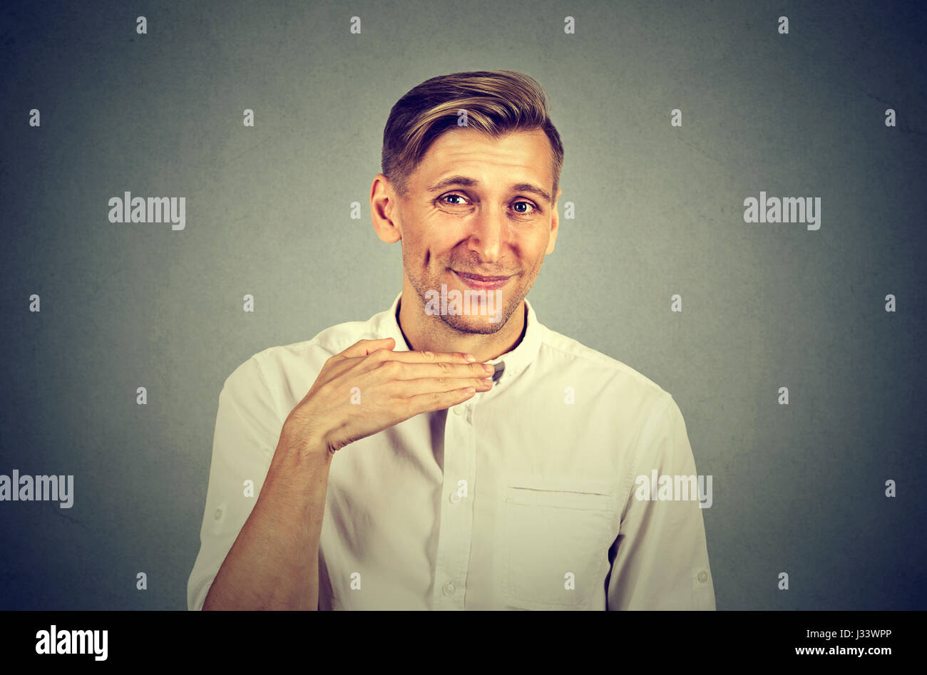 angry young man gesturing with hand to stop talking, cut it out ...