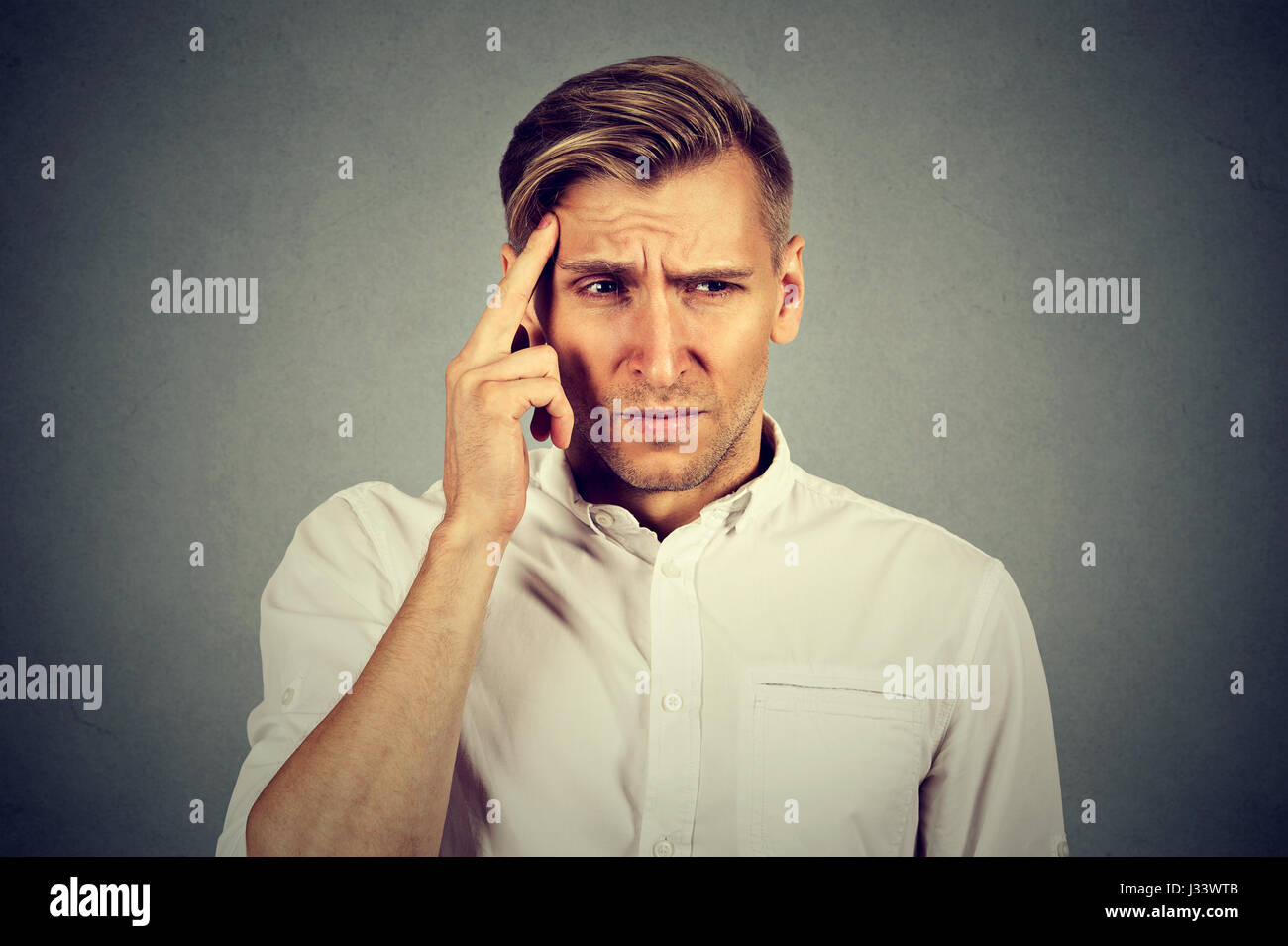 portrait stressed sad young man looking down isolated on gray wall ...