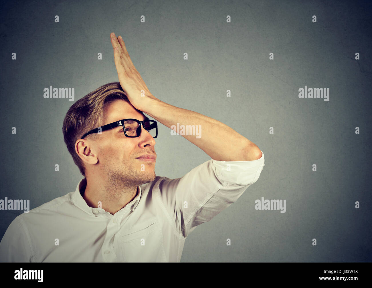 Regrets wrong doing. Silly young man, slapping hand on head having a ...