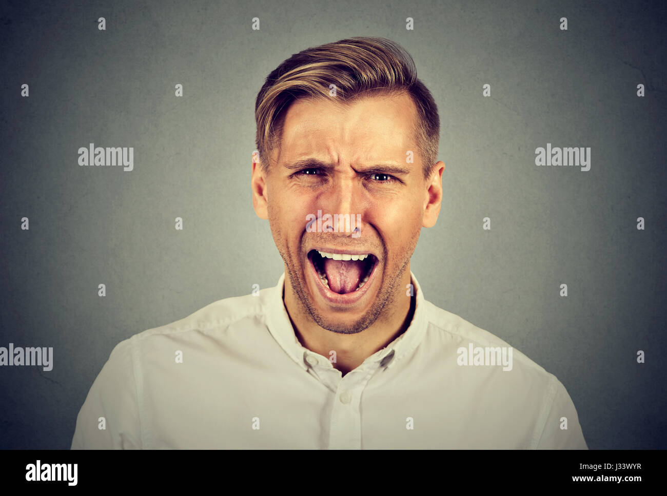 Angry young man screaming Stock Photo - Alamy