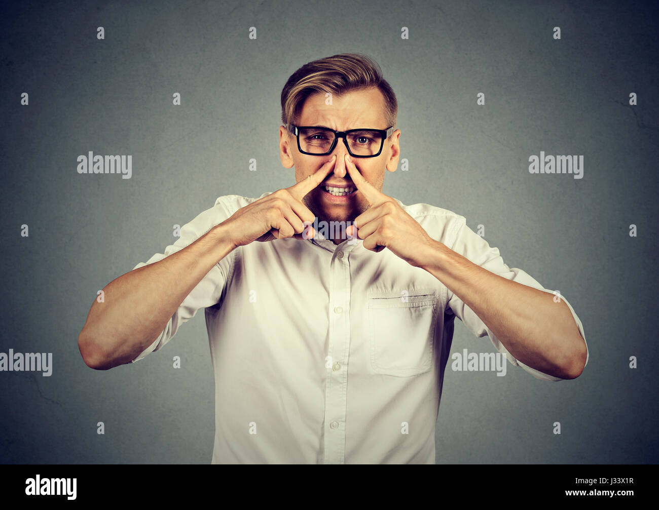 disgusted man pinches nose with fingers looks with disgust something ...