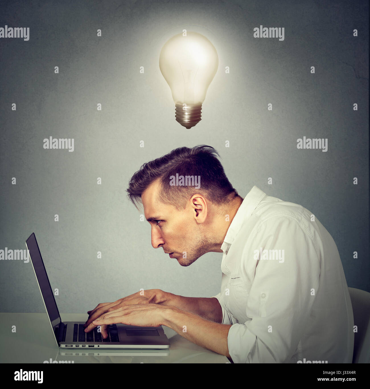 Side profile young man working on computer sitting at desk with light ...