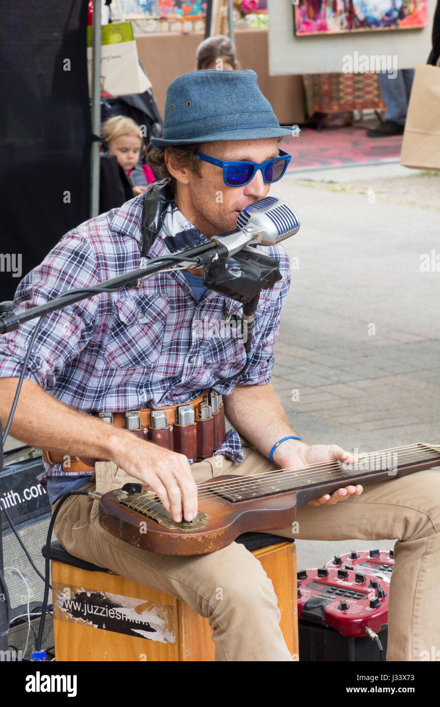 Busker singing and playing guitar music in Eumundi, Queensland ...