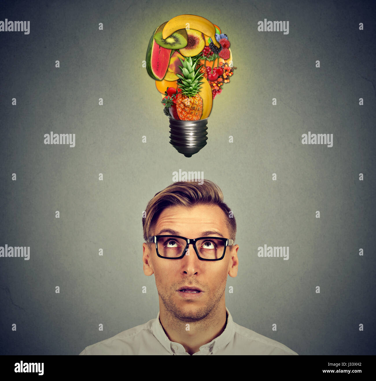 Eating healthy and diet tips concept. Man looking up at fruit light ...