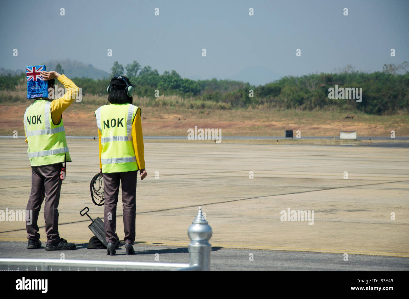 Thai aircraft marshaller marshalling and visual signal between ground ...