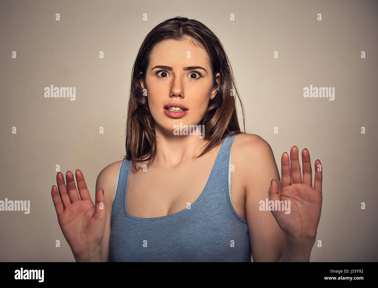 Concerned scared woman dodging something arms raised trying to avoid ...