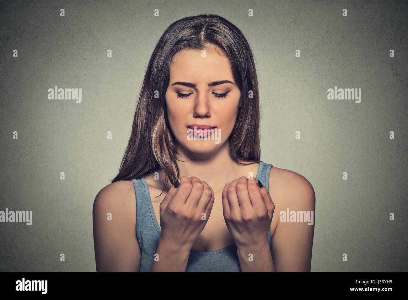 Worried woman looking at hands fingers nails obsessing about ...