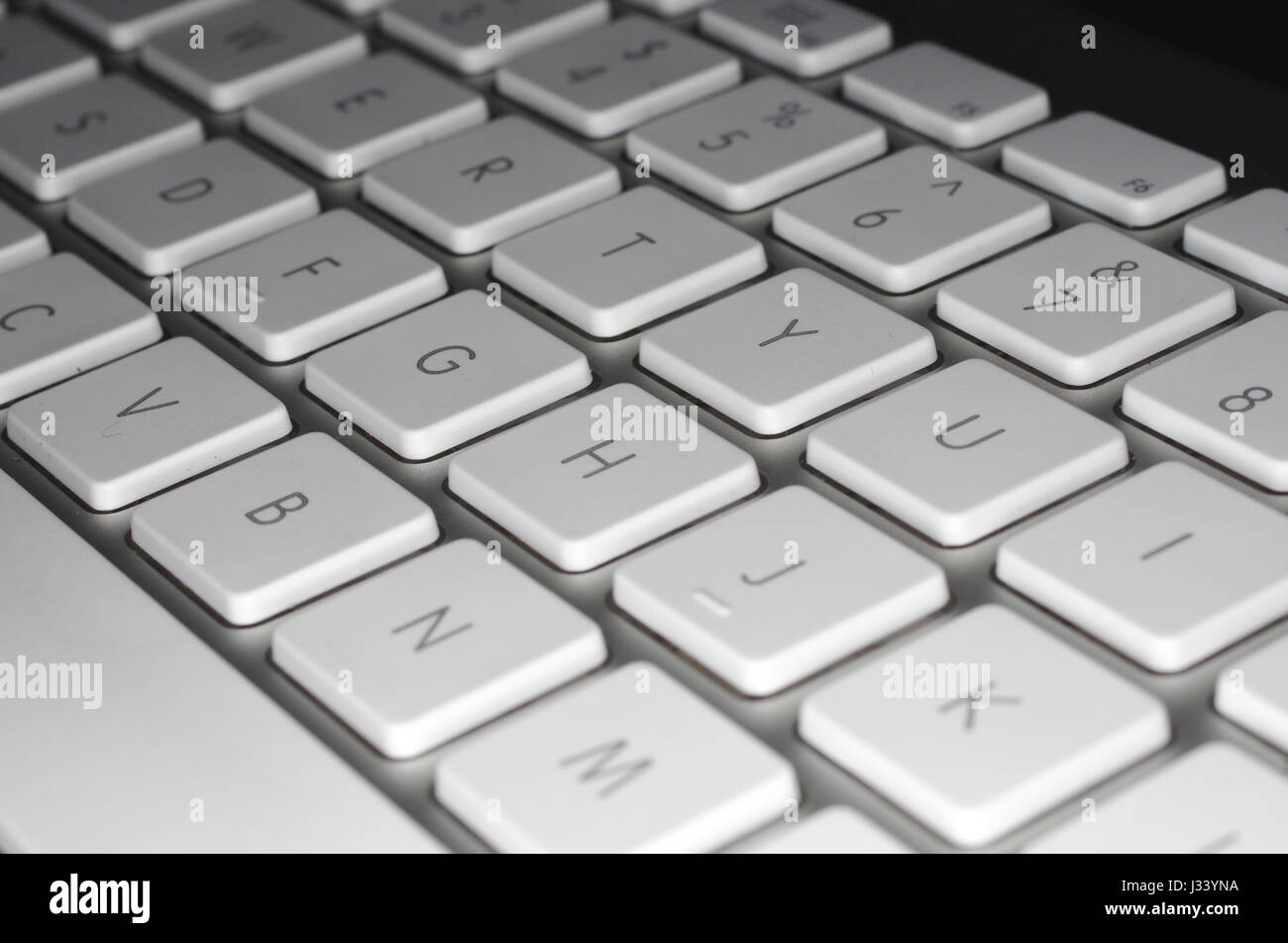 Close-up of white QWERTY keys on a silver wireless keyboard Stock Photo ...
