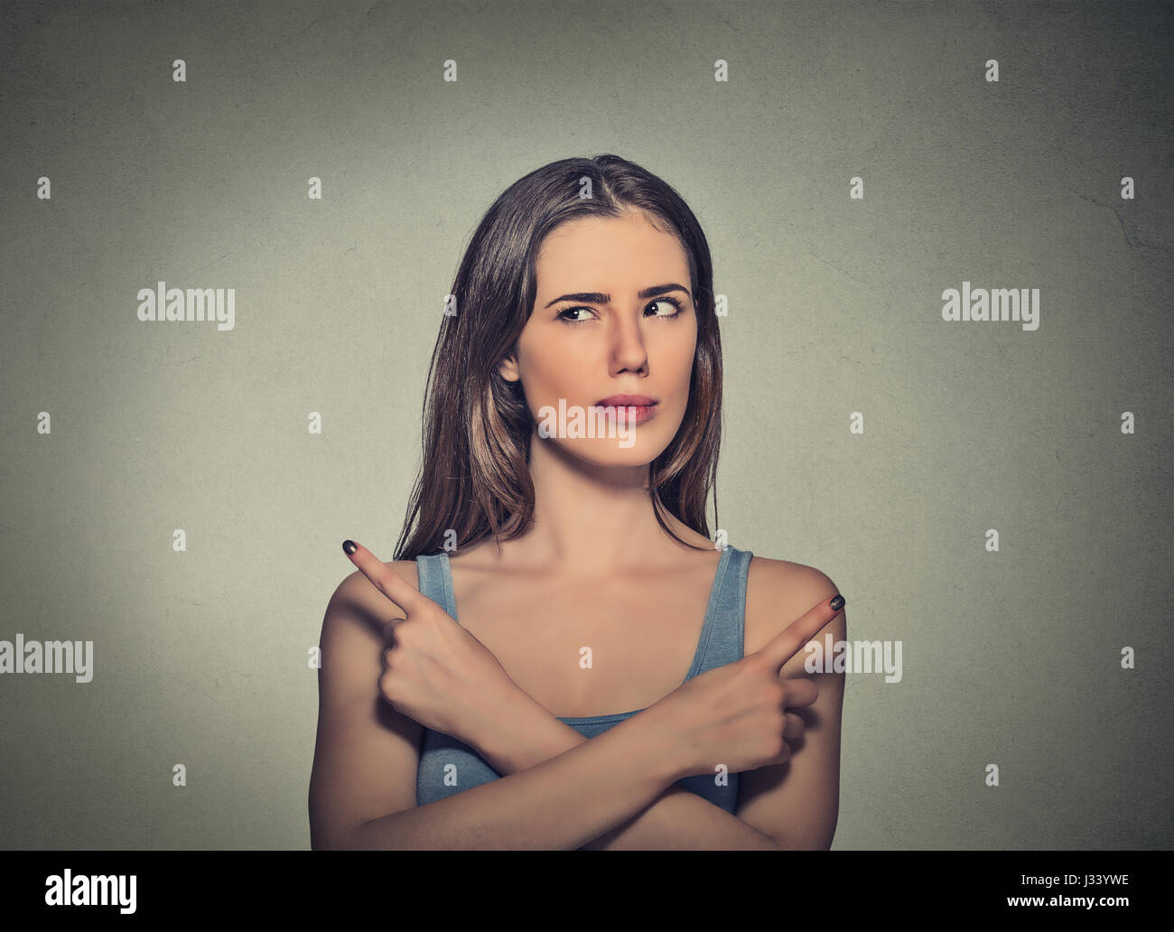 Portrait confused young woman pointing in two different directions not ...