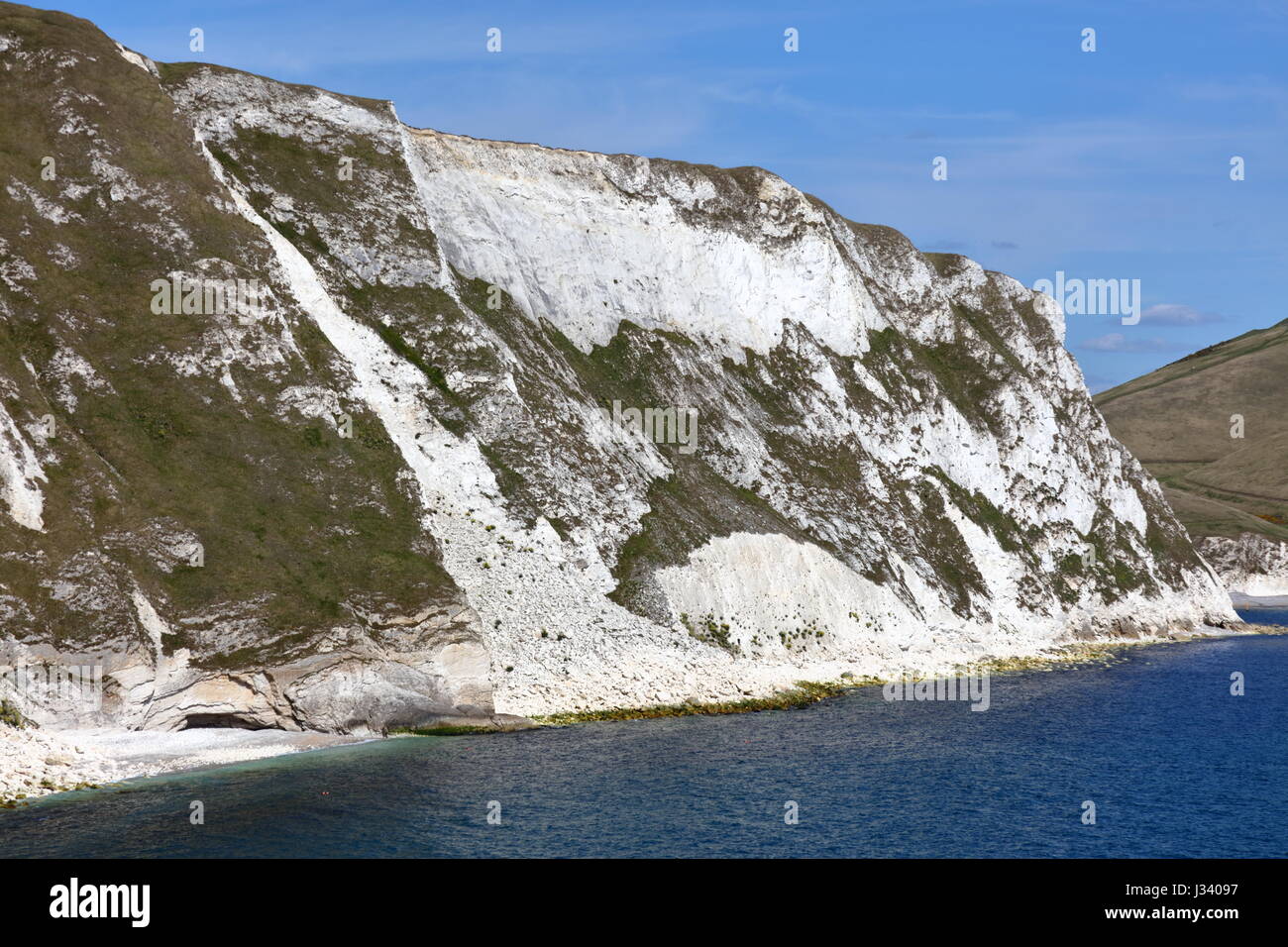 Crumbling chalk cliff face with well-established sea eroded talus cone ...