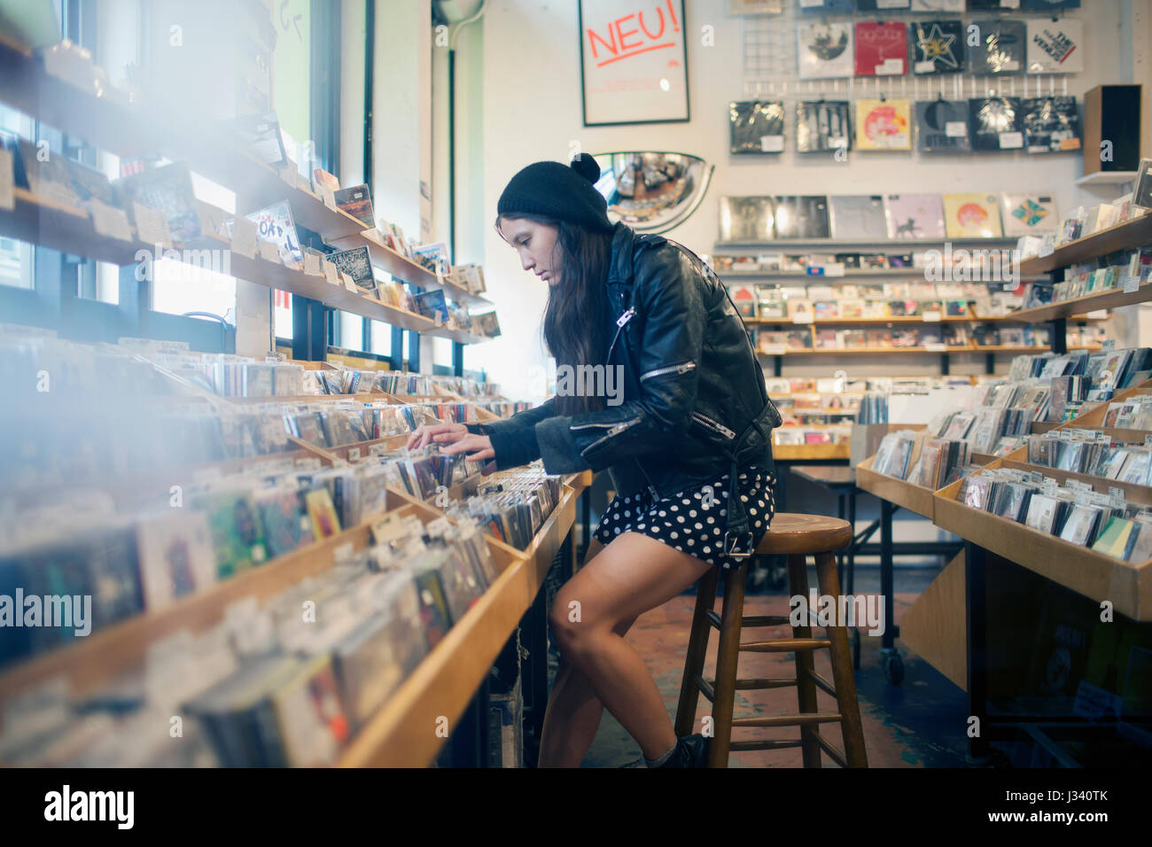 Young woman browsing albums in a record store Stock Photo - Alamy