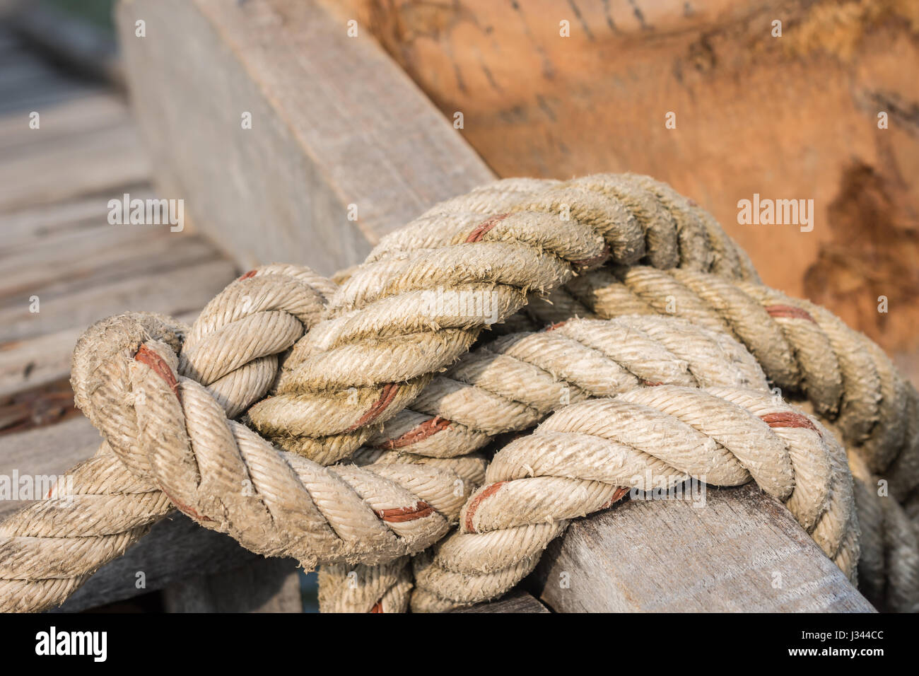 Rope tied up to a knot on a wood bridge Stock Photo - Alamy