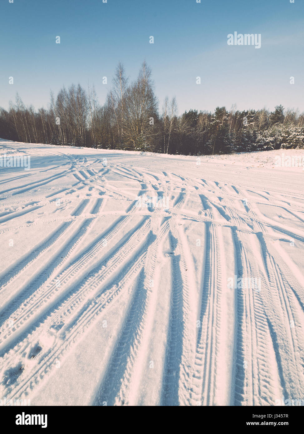 snowy winter road with tire markings and blue sky - retro vintage ...