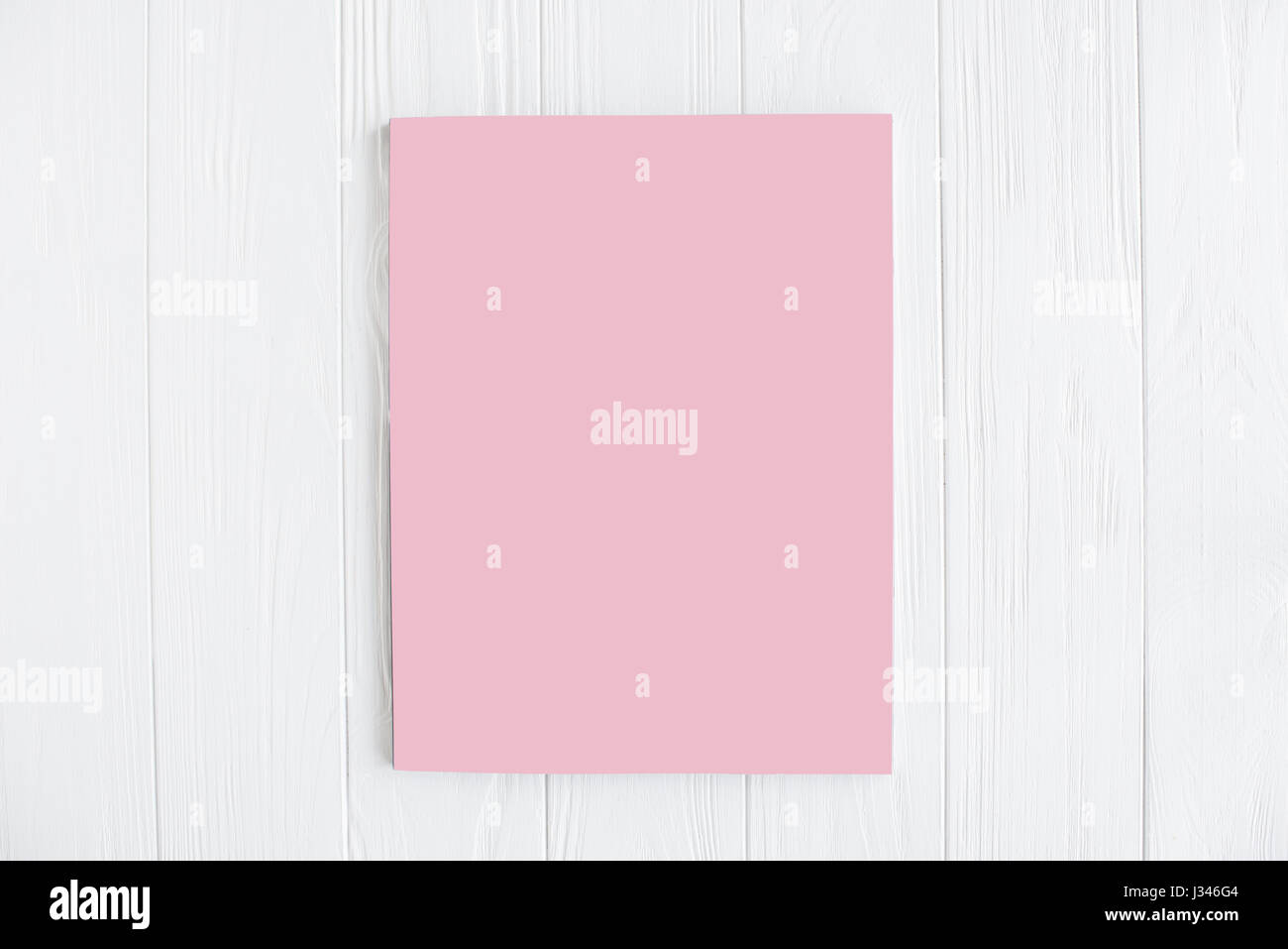 Pink isolated magazine cover mock-up on white wooden table board ...