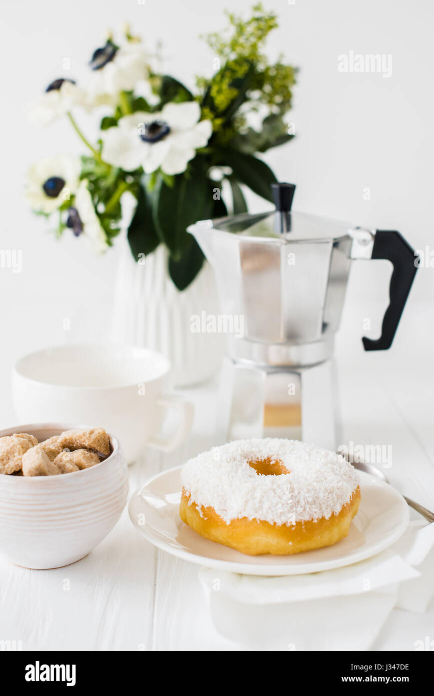 Elegant white breakfast table setting with flowers, coffee cup and ...