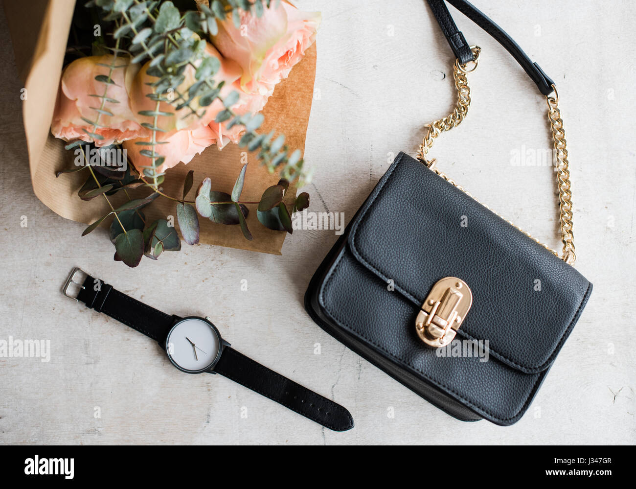 Feminine tabletop, flowers, elegant handbag and wrist watch on white ...