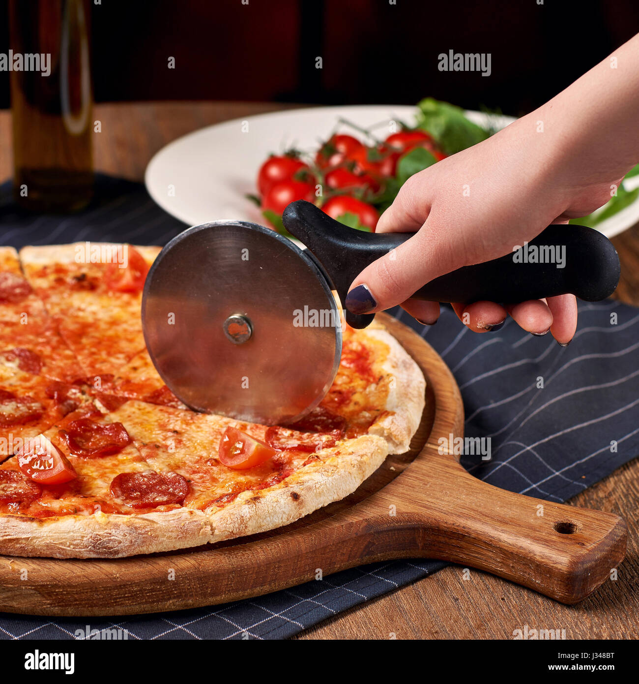 Cutting pizza on slices Stock Photo - Alamy