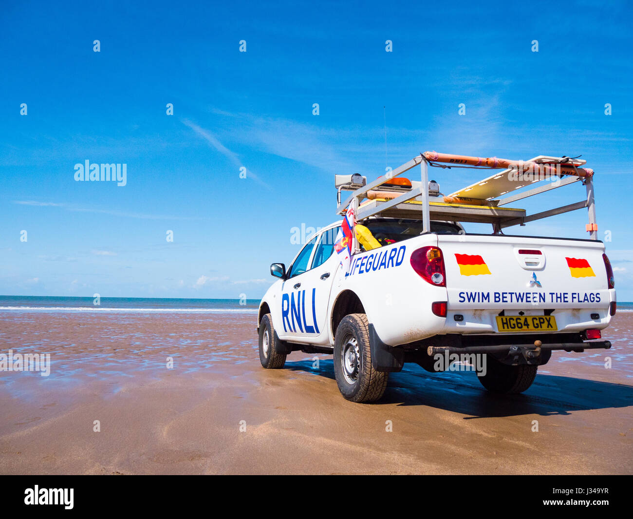 RNLI lifeguard pick up truck parked on Croyde beach near the surf on a ...