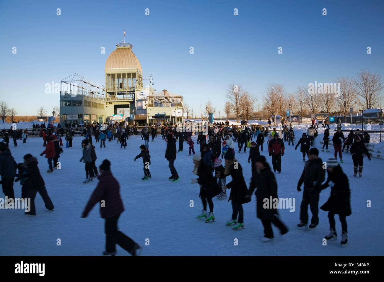 Silhouetted ice skaters at the Old Port skating rink, Old Montreal ...
