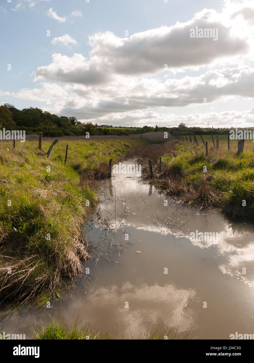 a stream running through the country with clouds reflected in it Stock ...