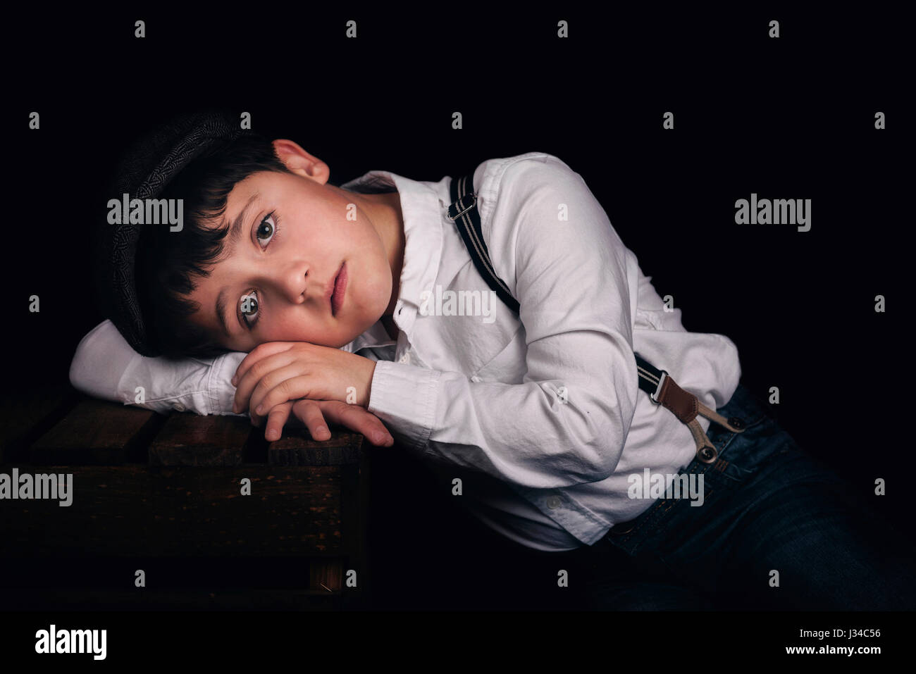 Pensive boy on black background Stock Photo - Alamy