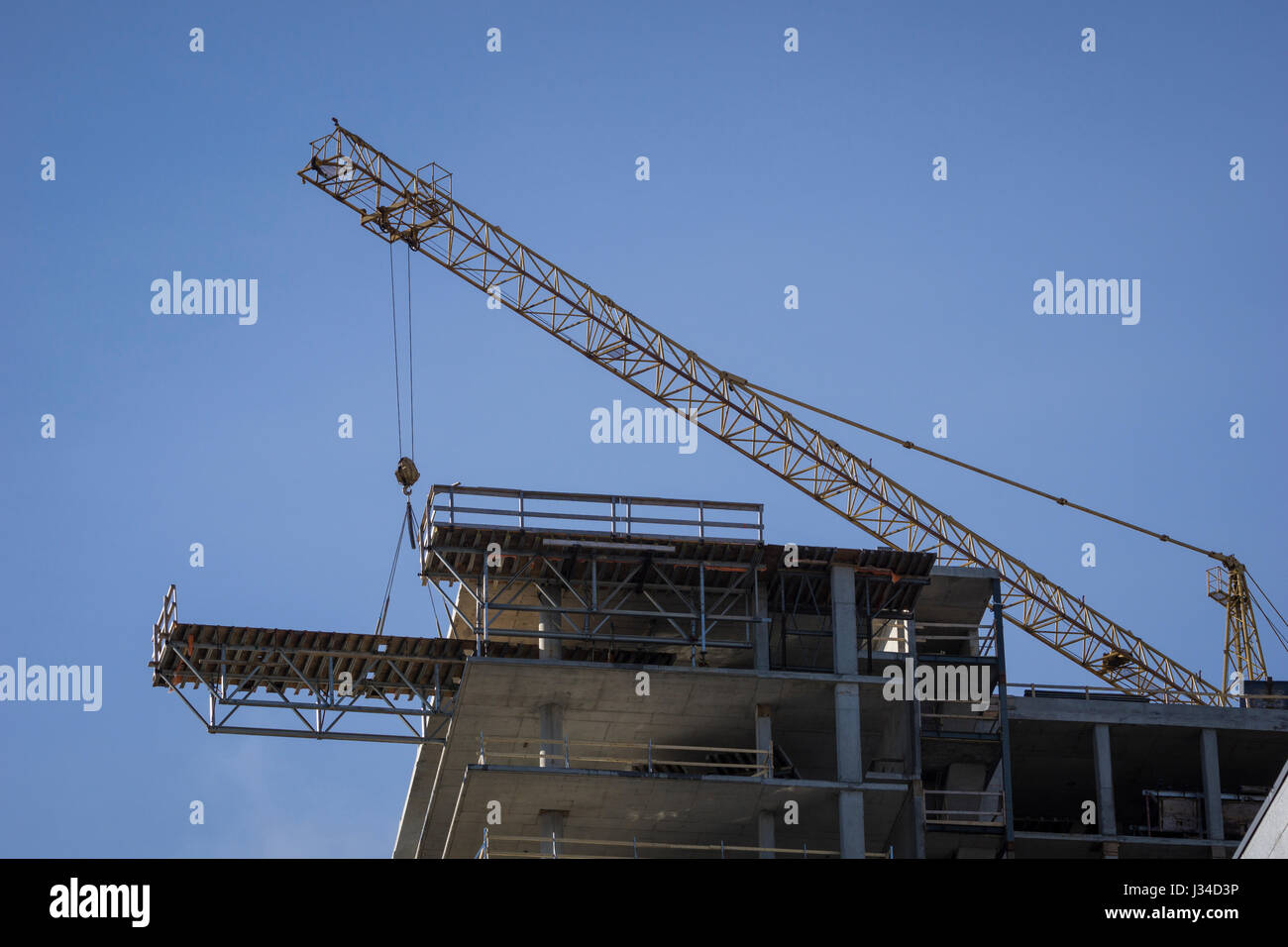 Tower crane moves a flying form used to support concrete pours in tall ...