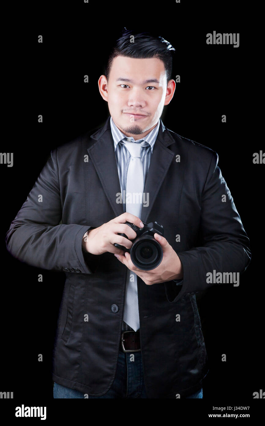 young asian man holding dslr camera take a photography by low key ,low ...