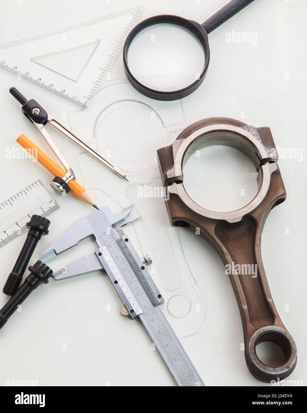 automotive engineering working table with engine piston and drawing ...