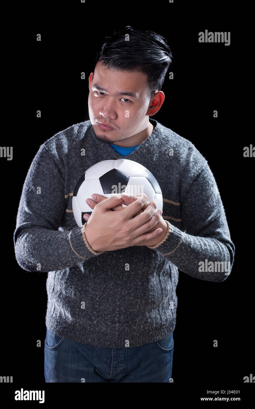 face of soccer lover holding football ball isolated black background ...