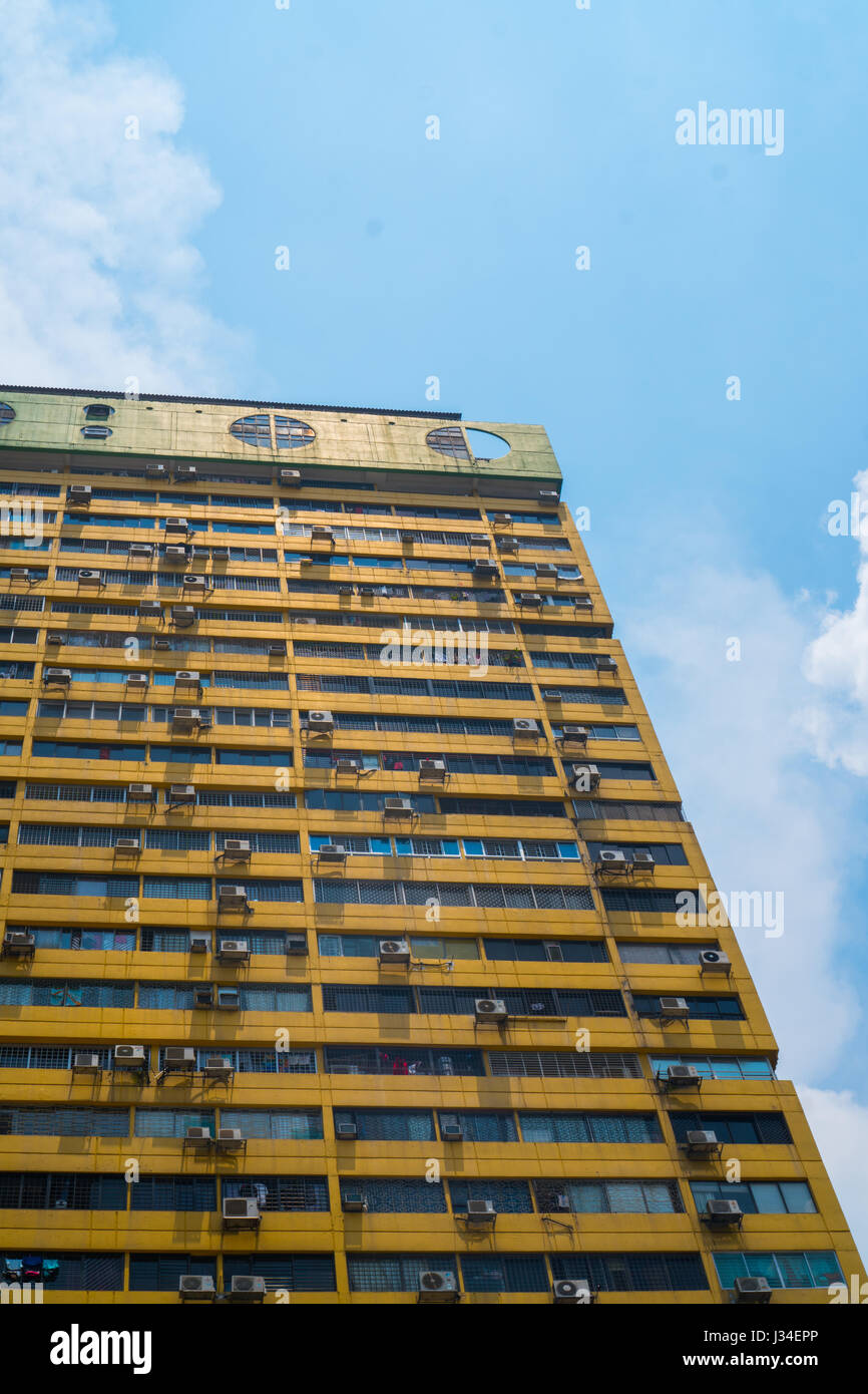The wall of yellow building with windows and air conditioners against ...