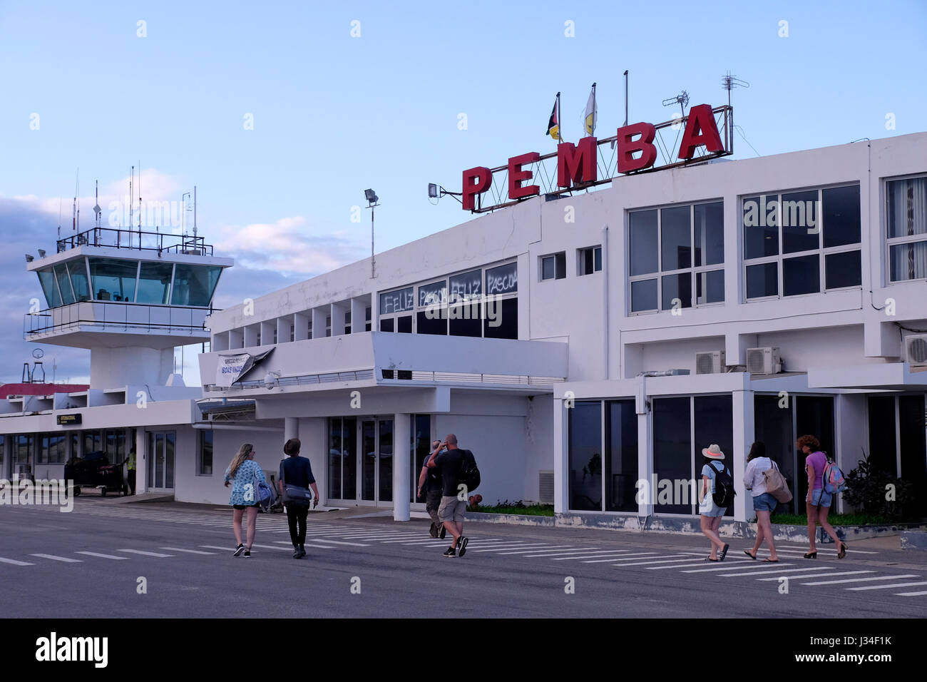 Arriving tourists walk to the small international airport in Pemba a ...