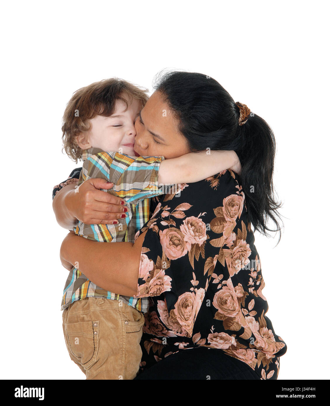 A Filipino nanny taking care of a three year old boy, hugging him ...