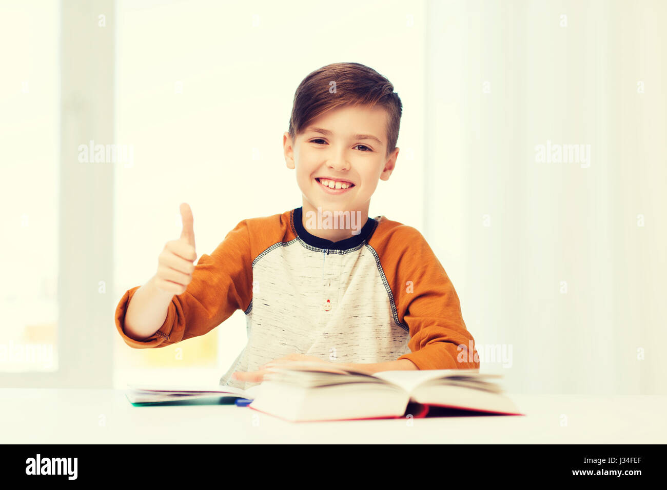 happy student boy with textbook showing thumbs up Stock Photo - Alamy